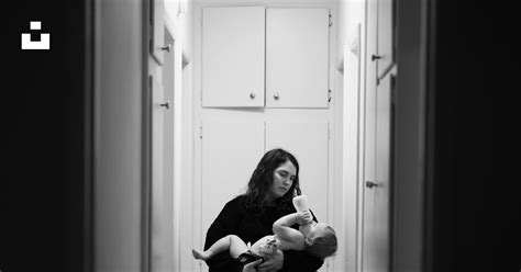 검은 긴 소매 셔츠를 입은 여자가 회색조 사진에서 아기를 안고 있다 사진 Unsplash의 무료 회색 이미지