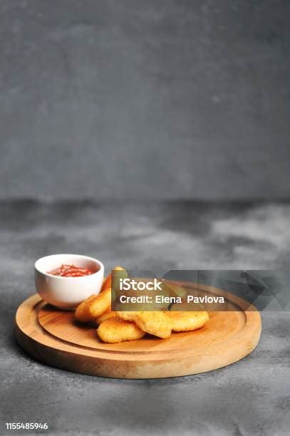 둥근 나무 판에 바삭바삭한 크러스트와 감자 튀김치킨 필레 조각 너겟 옆에는 케첩 한 잔이 있습니다 0명에 대한 스톡 사진 및 기타 이미지 Istock