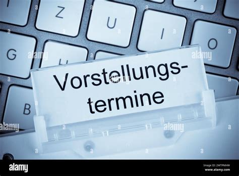 The Folder Of A Hanging File In Front Of A Computer Keyboard On The