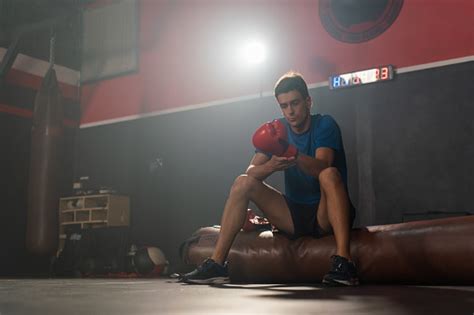 체육관에서 훈련 한 후 휴식을 취하기 위해 앉아있는 빨간 장갑을 착용 한 젊고 잘 생긴 남성 복서 권투 스포츠에 대한 스톡 사진 및 기타 이미지 Istock