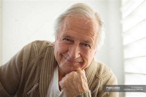 Portrait Of Smiling Senior Caucasian Man Looking At Camera And Touching