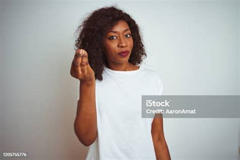 고립 된 흰색 배경 위에 서있는 티셔츠를 입은 젊은 아프리카 계 미국인 여성은 손과 손가락으로 자신감있는 표정으로 이탈리아