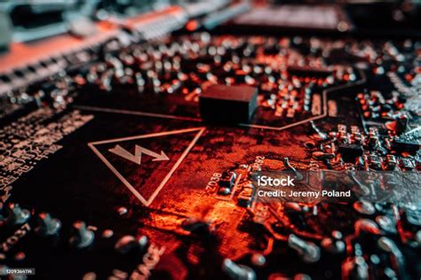 극적인 네온 컬러 조명 아래 칩 회로 기판 및 구성 요소를 보여주는 데스크톱 컴퓨터의 내부에 전원 공급 장치에 고전압 전기 경고 삼각형 기호의 매크로 클로즈업 샷 위험에