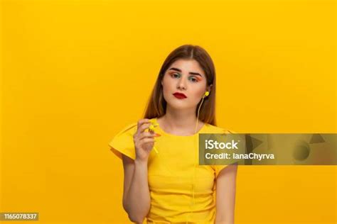 노란색 티에 행복한 젊은 모델은 노란색 배경 위에 서 유선 헤드폰으로 음악을 듣습니다 광고에 대한 스톡 사진 및 기타 이미지 광고 귀여운 긍정적인 감정 표현 Istock