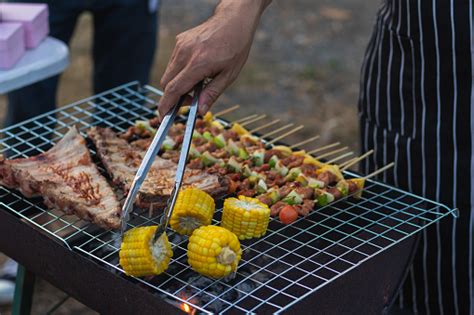 바베큐 파티를 위한 고기와 꼬치 재료를 그릴에 올려 바베큐를 요리하고 오늘 밤 가족이 바베큐 파티에 참여할 수 있도록 준비합니다