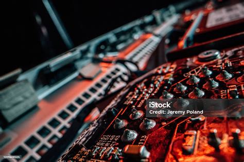 극적인 네온 컬러 조명 아래 칩 회로 기판 및 구성 요소를 보여주는 데스크톱 컴퓨터 내부의 전원 공급 장치에 납땜 포인트의 매크로 클로즈업 샷 0명에 대한 스톡 사진 및