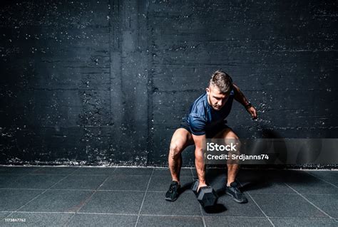 젊은 강한 맞는 근육 땀이 남자 와 큰 근육 강도 크로스 운동 훈련 아령 무게 와 체육관 어두운 이미지 와 그림자 실제 사람들