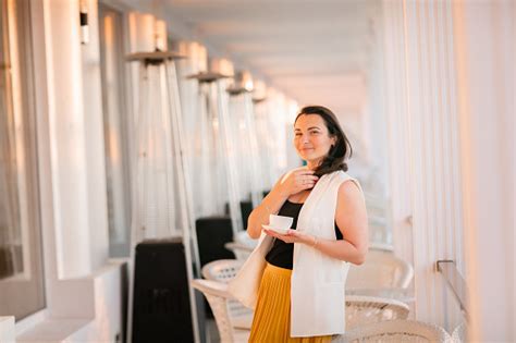 카푸치노 컵을 손에 들고 카페에서 포즈를 취한 노란 드레스의 세련된 미국 여성 갈색 머리에 대한 스톡 사진 및 기타 이미지 갈색 머리 귀여운 긍정적인 감정 표현