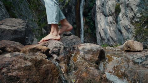 Barefoot Tourist Walk Rocks Crossing Mountain River With Waterfall On