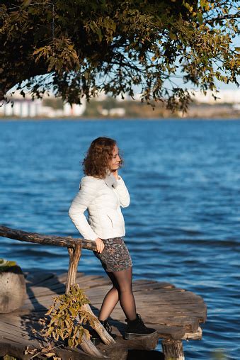 가을에 공원에서 호수 근처를 걷는 흰색 재킷을 입은 젊은 빨간 머리 여성 여자에 대한 스톡 사진 및 기타 이미지 여자 호수 10월 Istock