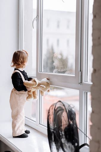 내가 제일 좋아하는 장난감 귀여운 어린 2 세 소녀는 그녀의 테디 베어를 껴안고 미소 장식 베이지 색 스튜디오 배경 큰 창문 근처에서 웃는 아이 18 23 개월에 대한 스톡