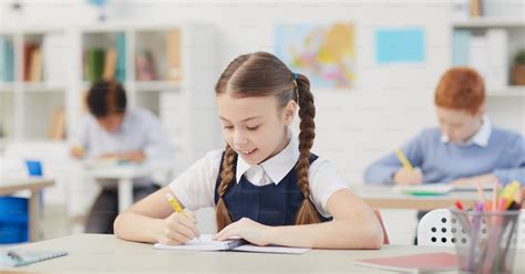 책상에 앉아 공책에 메모를 하는 여학생 그녀는 학교에서 수업 중에 일하고 있다 사진 Unsplash의 러시아 이미지