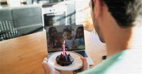 노트북과 케이크를 들고 집에서 화상 통화로 생일을 축하하는 청년의 초상화 새로운 정상적인 라이프 스타일 개념입니다 사진 Unsplash의 코비드 19 이미지