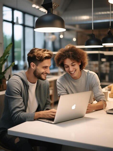Premium Photo Cheerful Male And Female Computer Programmers Discussing Over Laptop In New Office
