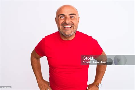 얼굴에 행복하고 시원한 미소와 고립 된 흰색 배경 위에 서 빨간색 캐주얼 티셔츠를 입고 중년 잘 생긴 남자 운이 좋은 사람 T 셔츠에 대한 스톡 사진 및 기타 이미지