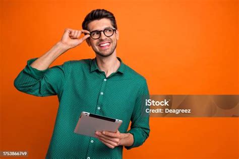 꿈꾸는 사려 깊은 남자의 사진 녹색 셔츠 타이핑 현대 가제트 찾고 빈 공간 고립 된 주황색 배경 25 29세에 대한 스톡 사진