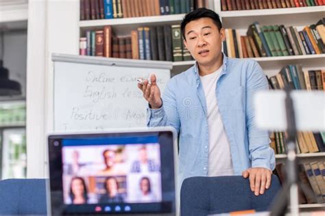Chinese Teacher Having Distance Class Making Group Video Call Indoors