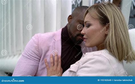 Pair Of Black Man And Blonde Woman Embracing Outdoors Multiracial
