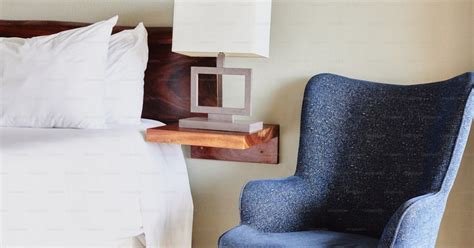 침실의 침대 옆에 앉아 있는 파란색 의자 사진 Unsplash의 침대 이미지