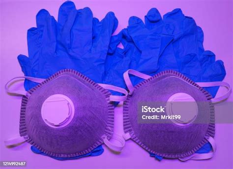 Ffp2 의료 용 마스크와 일회용 블루 의료 장갑 세트 오염 바이러스 독감 및 코로나 바이러스에 대한 얼굴 마스크 보호 건강 관리 및 수술 개념 보라색 빛 콘테스트