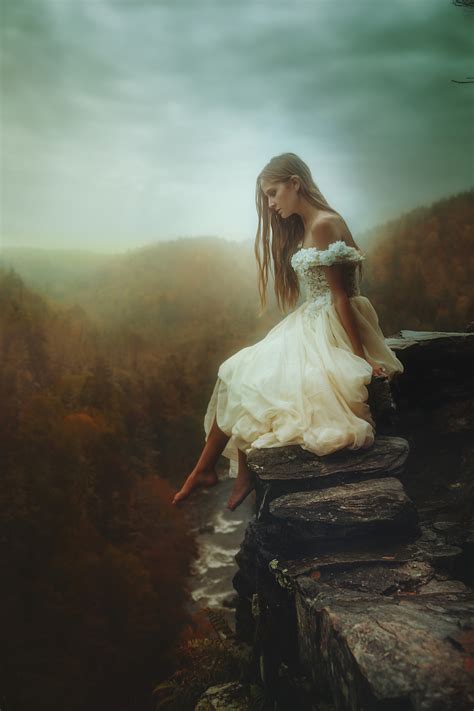 Фото Девушка сидит на краю скалы By Tj Drysdale