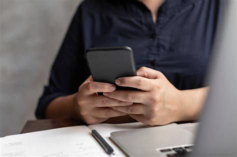 익명 플러스 크기 여자 커피 숍에 앉아 그녀의 노트북에서 작업 하는 동안 그녀의 스마트폰에 웹을 검색 노트북에 대한 스톡 사진