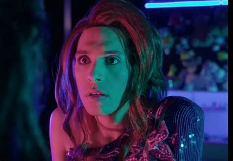 A Woman With Blue And Red Light On Her Face Looking At The Camera In A