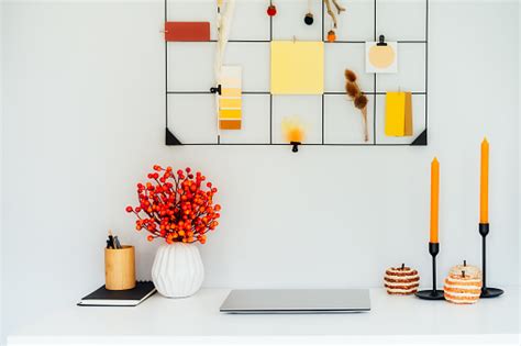 닫힌 노트북이 있는 홈 오피스 책상 가을 색상 팔레트 노트 모형 양초 꽃 호박과 같은 계절 장식이 있는 그리드 무드 보드 가을의 영감과 아늑한 분위기 Hygge 가정 가을