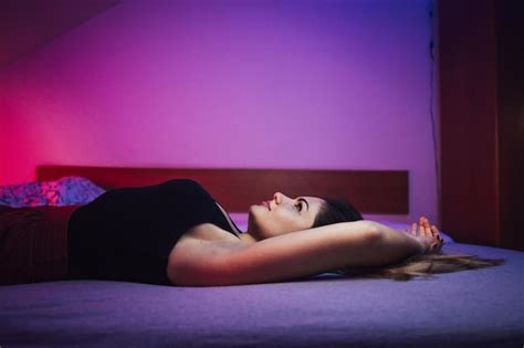 Premium Photo Side View Of Young Woman Relaxing On Bed At Home