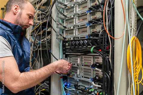 The Man Serves The Server Hardware A Technician Switches Internet Wires In A Server Room The