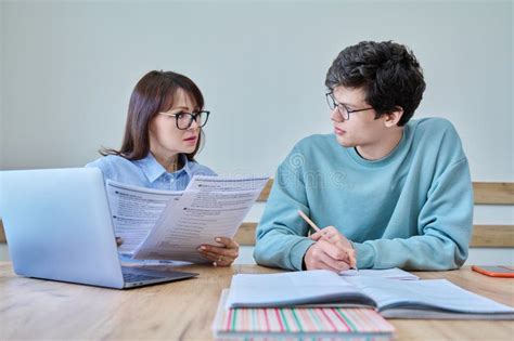 Young Teenage Male Studying Languages With Teacher In Classroom Stock