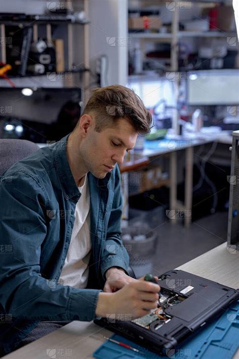 在专业服务中心修理和诊断笔记本电脑故障。车间的专业电子硕士，使用不同的工具或仪器。计算机维修概念