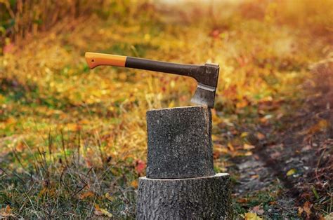Premium Photo Ax With An Orange Handle Is Driven Into Wooden Log