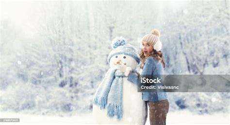 따뜻한 겨울 옷을 입고 겨울 눈 속에서 눈사람을 만드는 것을 즐기는 행복한 젊은 여자 겨울 시즌의 크리스마스 휴가 기간 동안 스키 여행 냉각 및 가열 온도 개념 건축하기에