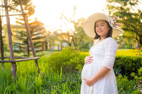 임산부는 아이를 돌보면서 정원에서 새로운 삶에 행복을 느낍니다 임신 한 배에 아기를 들고 젊은 기대 어머니 출산 전 관리 및 여성 임신 개념 개념에 대한 스톡 사진 및 기타
