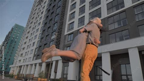 Shot From The Lower Angle A Young Guy Picks Up A Curly Girl In His