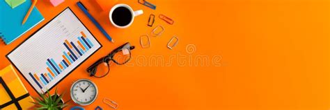 Office Desk With Charts Glasses And Coffee On An Orange Background