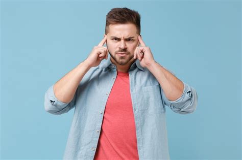 파스텔 파란색 배경 스튜디오 초상화에 격리된 채 캐주얼 셔츠를 입은 불만족스러운 젊은 남자 사람들은 진실한 감정 라이프 스타일