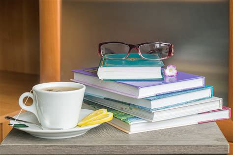 테이블 표면에는 독서용 책 더미 뜨거운 차 한 잔과 함께 여성용 안경이 있습니다 0명에 대한 스톡 사진 및 기타 이미지 0명 가구 가정의 방 Istock
