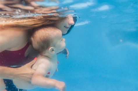 엄마는 아들 물에 포장 되어있습니다 얕은 수영장에서 물 속에서 수영을 보유 하고있다 다이빙 아기입니다 수영 학습 유아 아이입니다 젊은 어머니 또는 수영 강사 행복 한 어린