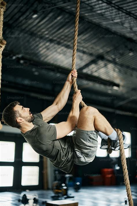 체육관에서 크로스 트레이닝을 하는 동안 로프를 오르는 운동 선수 사진 Unsplash의 세르비아 이미지