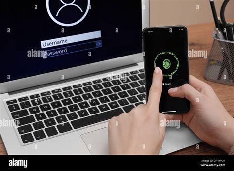 Woman Unlocking Smartphone With Fingerprint Identification Near Laptop At Workplace Closeup