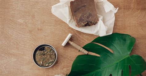 제로 폐기물 개념 플랫 레이 천연 비누 금속 주석의 고체 샴푸 재사용 가능한 면도기 녹색 몬스테라 잎이 있는 나무 배경에 우탄 플라스틱 프리 뷰티 필수품