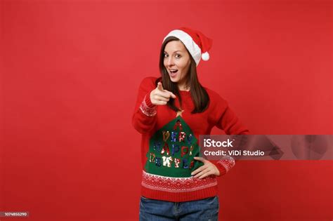 크리스마스 모자 카메라 빨간 배경에 고립에 입 벌리고 포인팅 검지 손가락을 유지 젊은 산타 여자 흥분 행복 한 새 해 2019 축 하 휴일 파티 개념입니다 복사 공간을