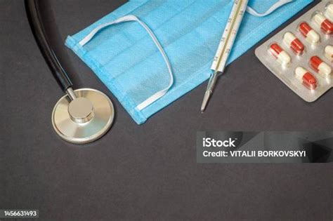 의료 외과 의사 마스크 독감 및 코로나 바이러스 보호는 검은색 배경에 온도계와 청진기로 격리됩니다 건강 관리 개념입니다 텍스트 공간을 복사합니다 0명에 대한 스톡 사진 및