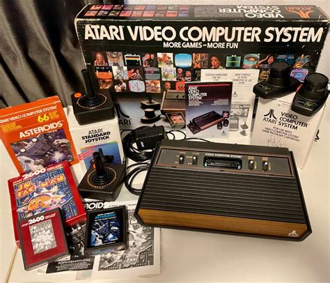 Atari 2600 •woody• Cib •as New• Including 2 Joysticks Paddleset And 2 Boxed Games Asteroids