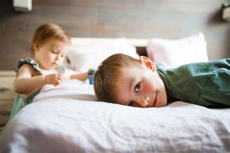 La Hermanita Juega Con Su Hermano Mayor En Casa Imagen De Archivo Imagen De Hermana Acogedor