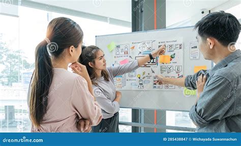 Group Of Asian Ux Developer And Ui Designer Serious Brainstorming About Mobile App Interface On