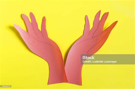 광산 공간의 밝은 노란색 배경에 빨간 종이로 만든 열린 손바닥 컨셉의 상징은 밝은 배경에 빈 공간을 들고 있는 두 손으로 구성됩니다 3차원 형태에 대한 스톡 사진 및 기타