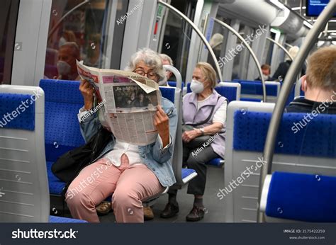 People Reading Newspaper On Train